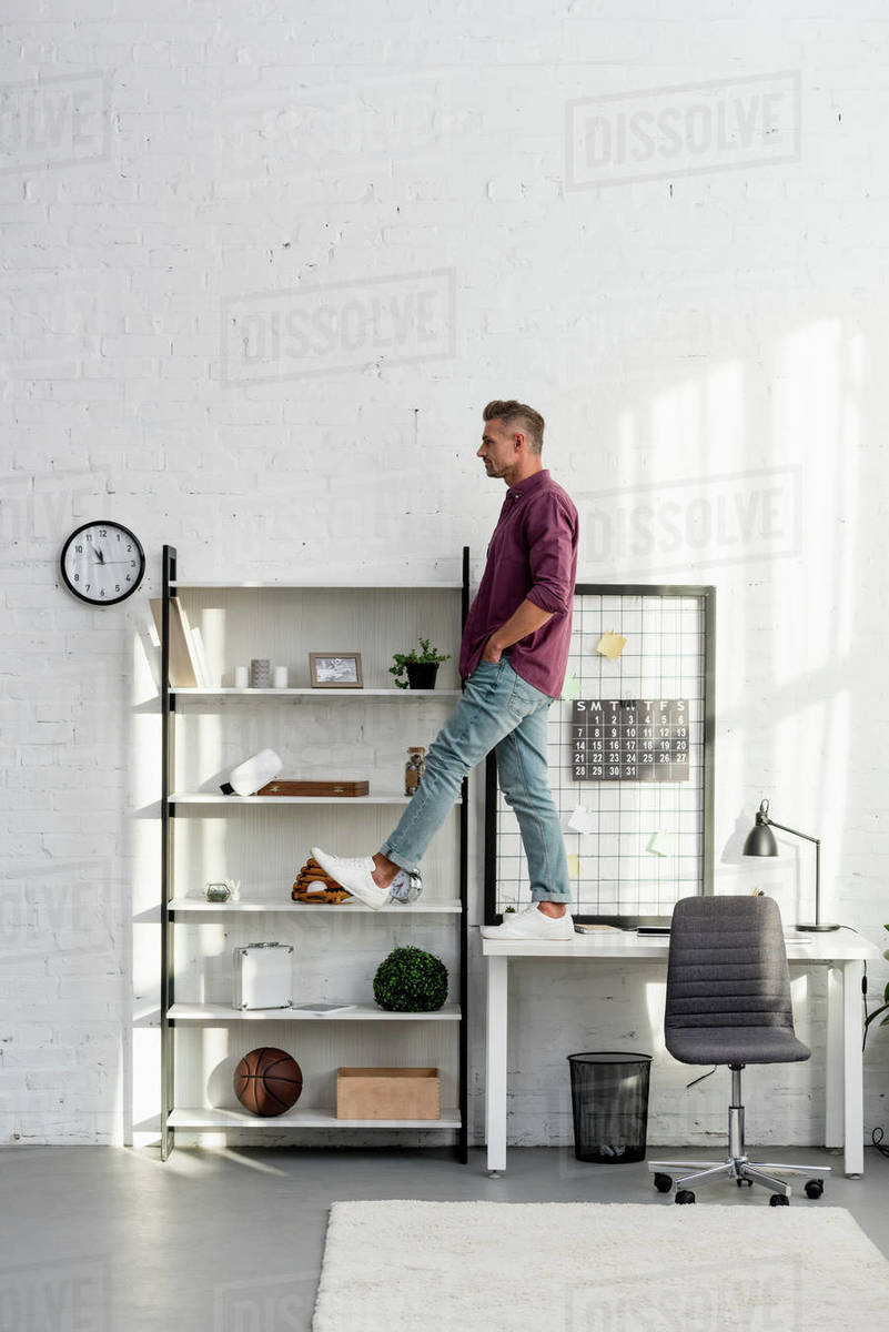 Man stepping from desk at home office - Stock Photo - Dissolve