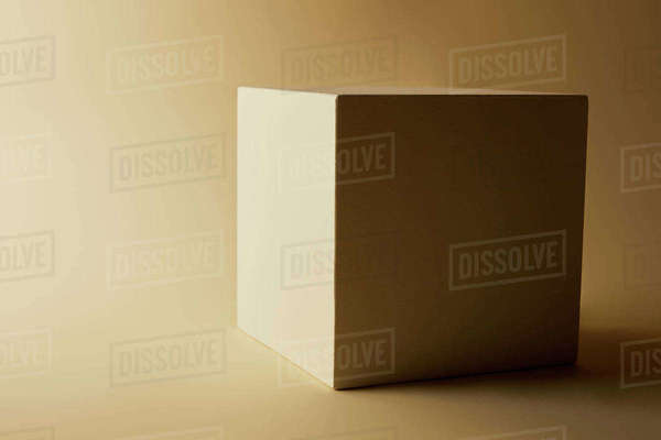 Close-up shot of cube on beige surface - Stock Photo - Dissolve