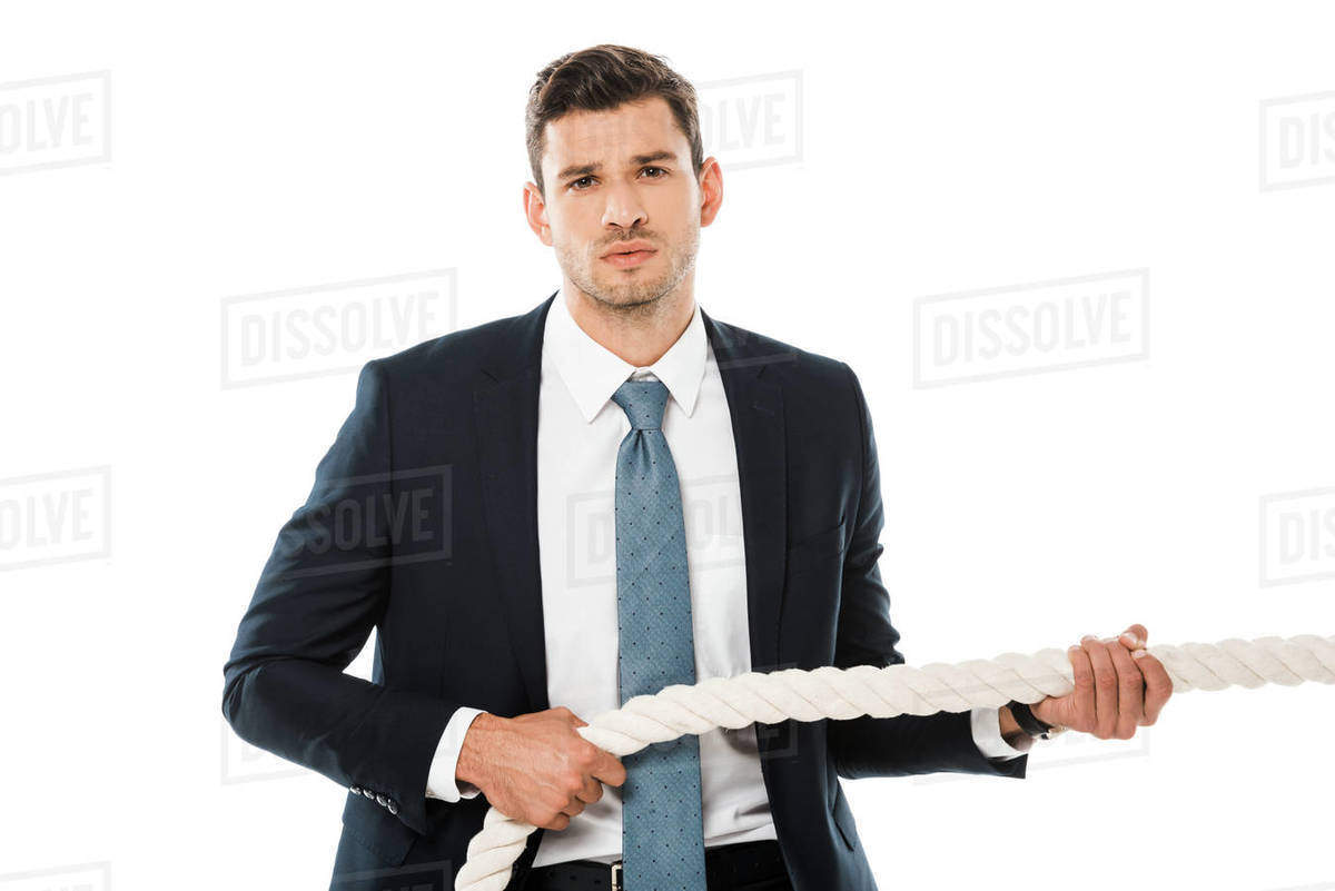 tense businessman pulling rope and looking at camera isolated on white ...