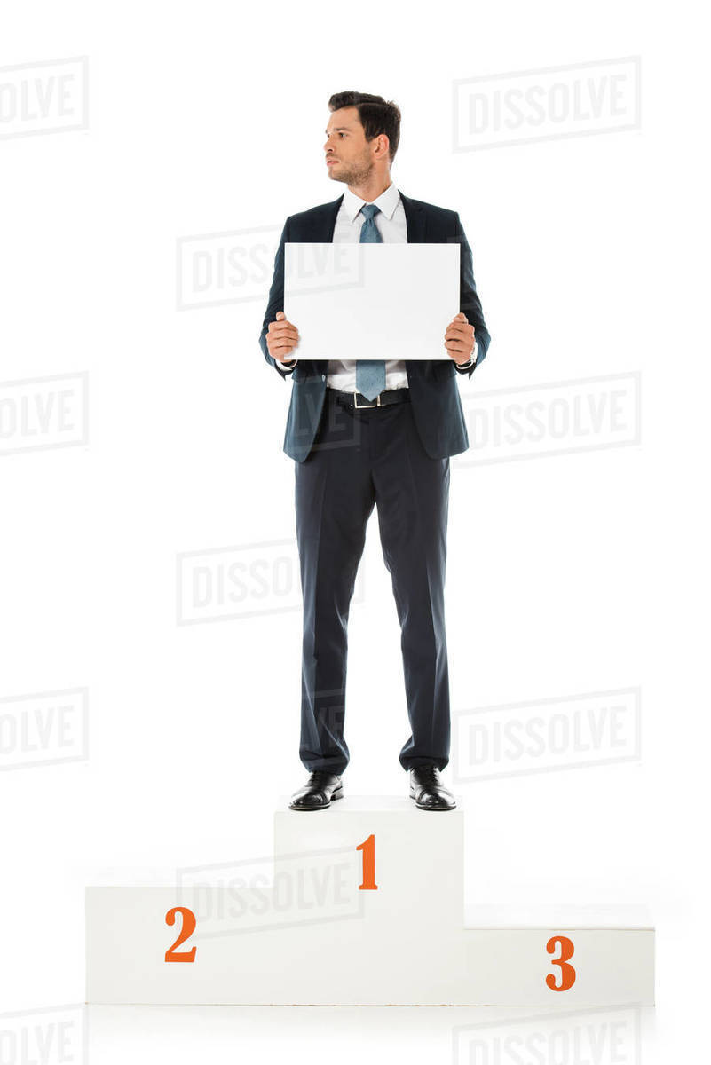 handsome businessman holding blank placard while standing on winners ...