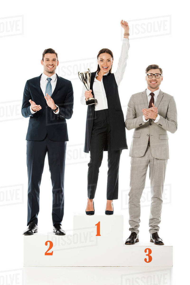professional businesspeople holding awards while standing on winners ...