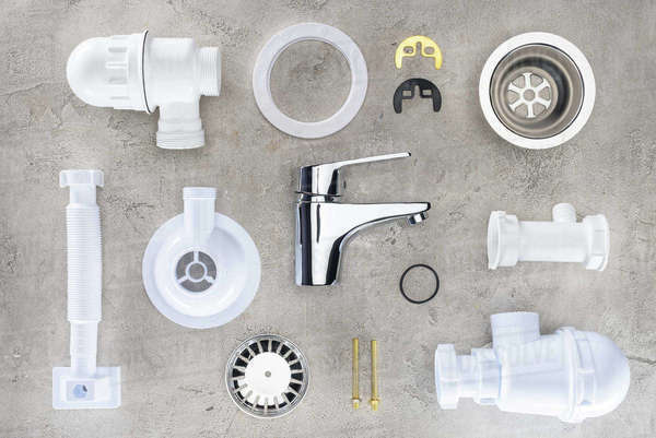 top view of water mixer surrounded with various plumbing pieces on ...