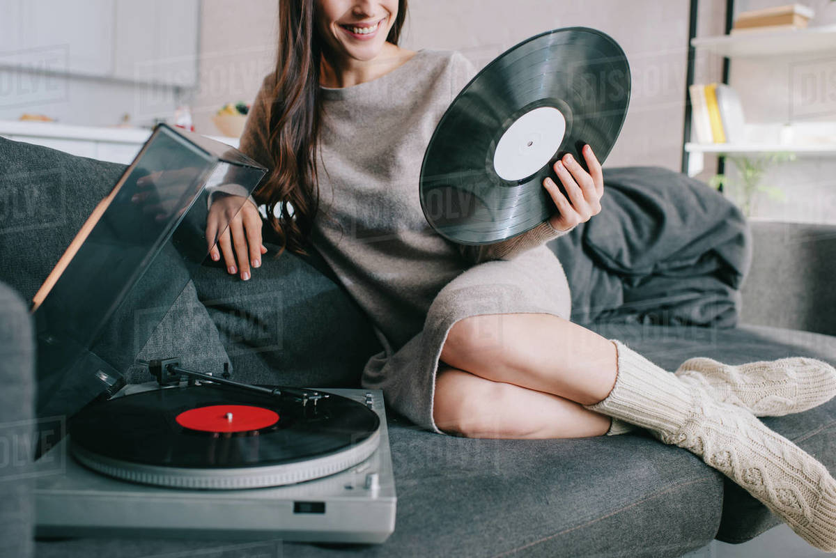 Cropped shot of young woman listening music with vinyl record player on ...