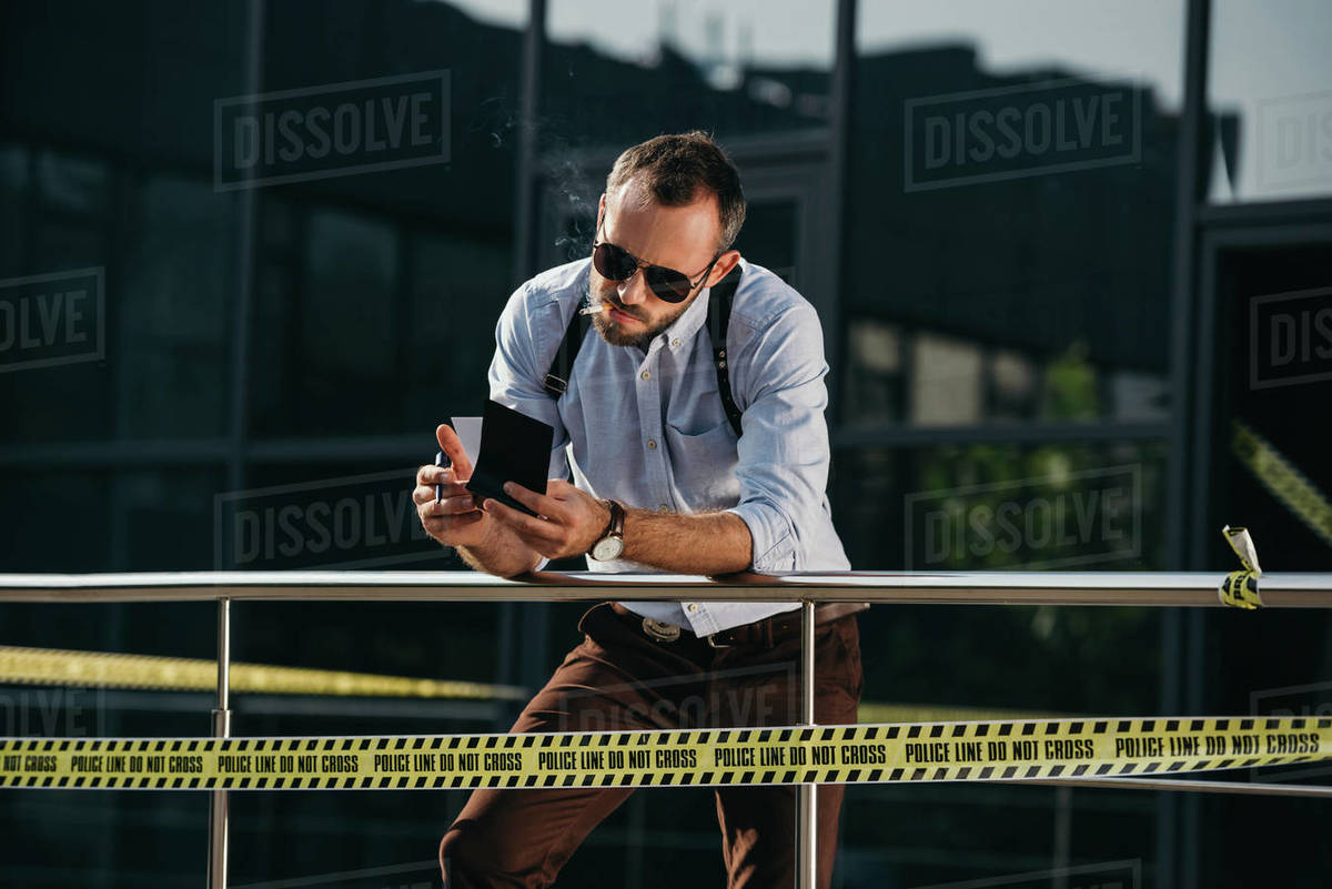 Male detective in sunglasses smoking and review notes - Royalty-free ...