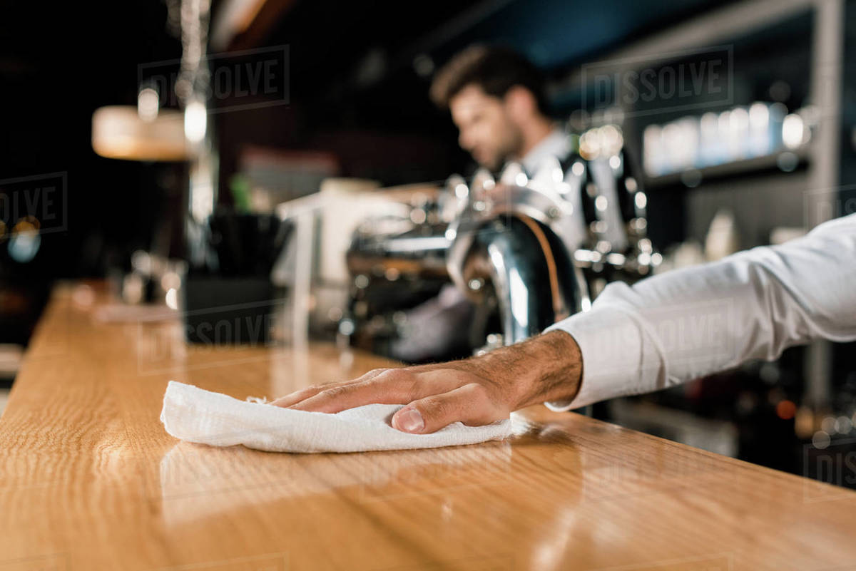 Close up of male hand cleaning wooden bar counter - Royalty-free Stock ...