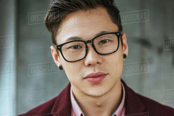 close-up portrait of handsome young asian man in eyeglasses looking at ...