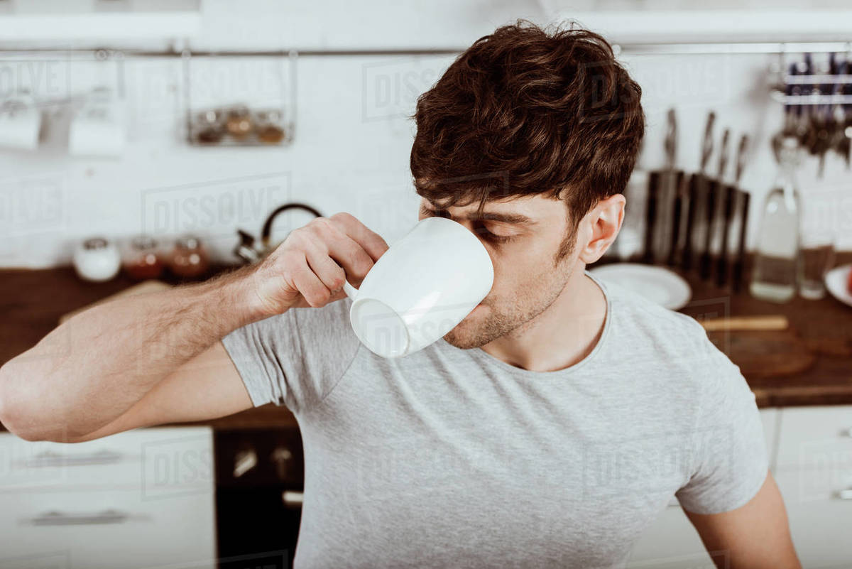 high angle view of man drinking coffee on breakfast in kitchen at home ...