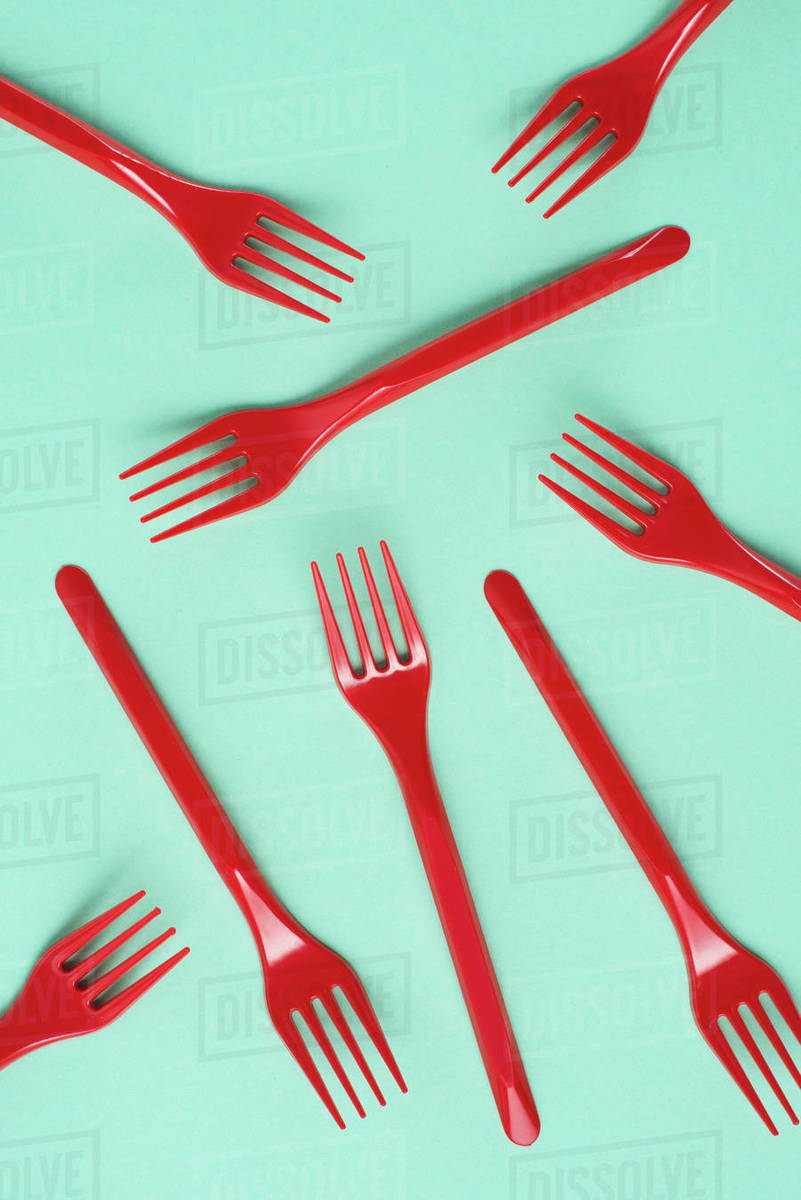 Top view of red plastic forks scattered on blue background - Royalty ...