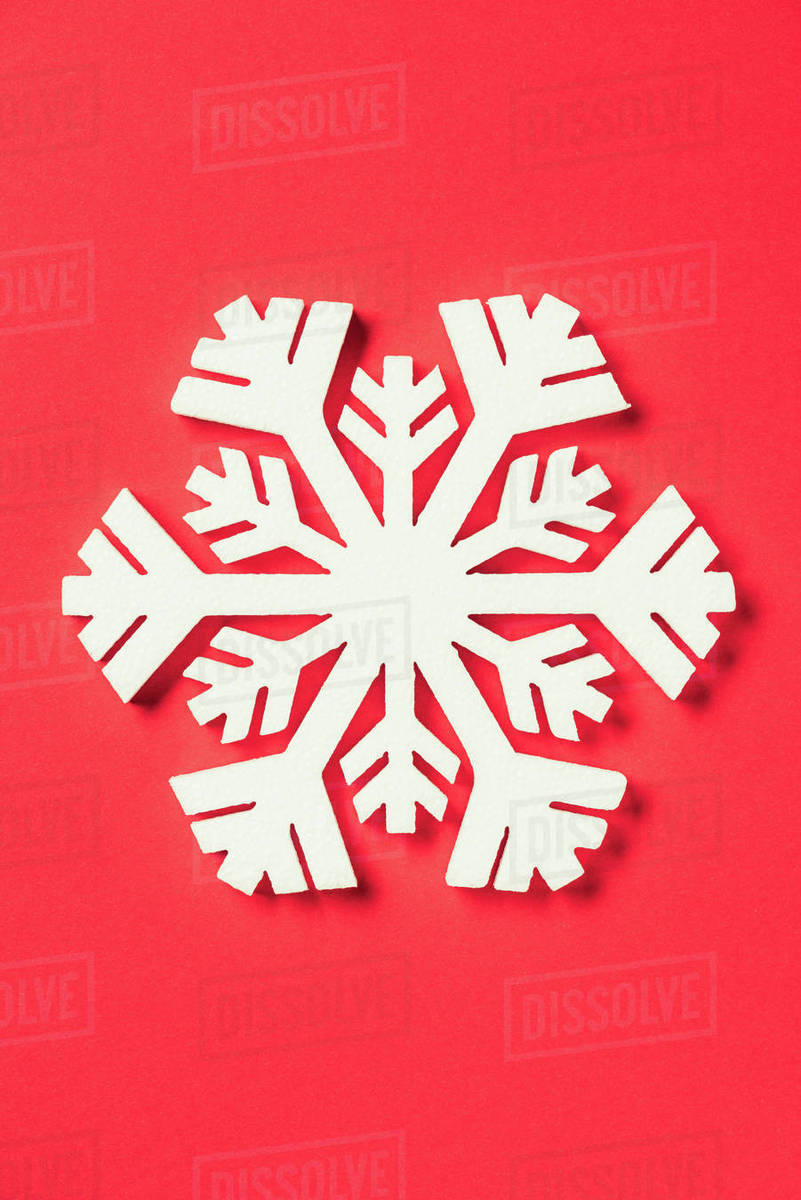 top view of paper snowflake on red background - Stock Photo - Dissolve