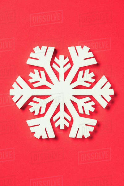 top view of paper snowflake on red background - Stock Photo - Dissolve