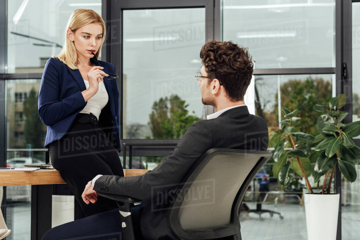 Attractive businesswoman flirting with business colleague at workplace ...