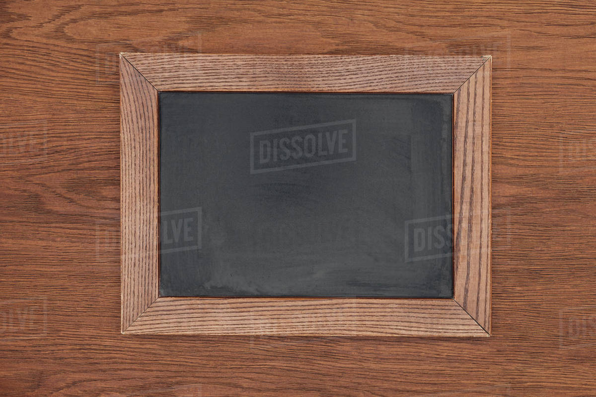 Top view of empty chalk board on wooden background - Stock Photo - Dissolve