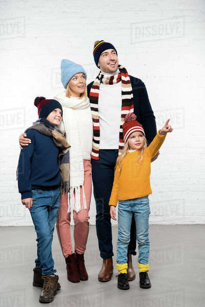 Smiling family in casual clothes looking away on white background ...