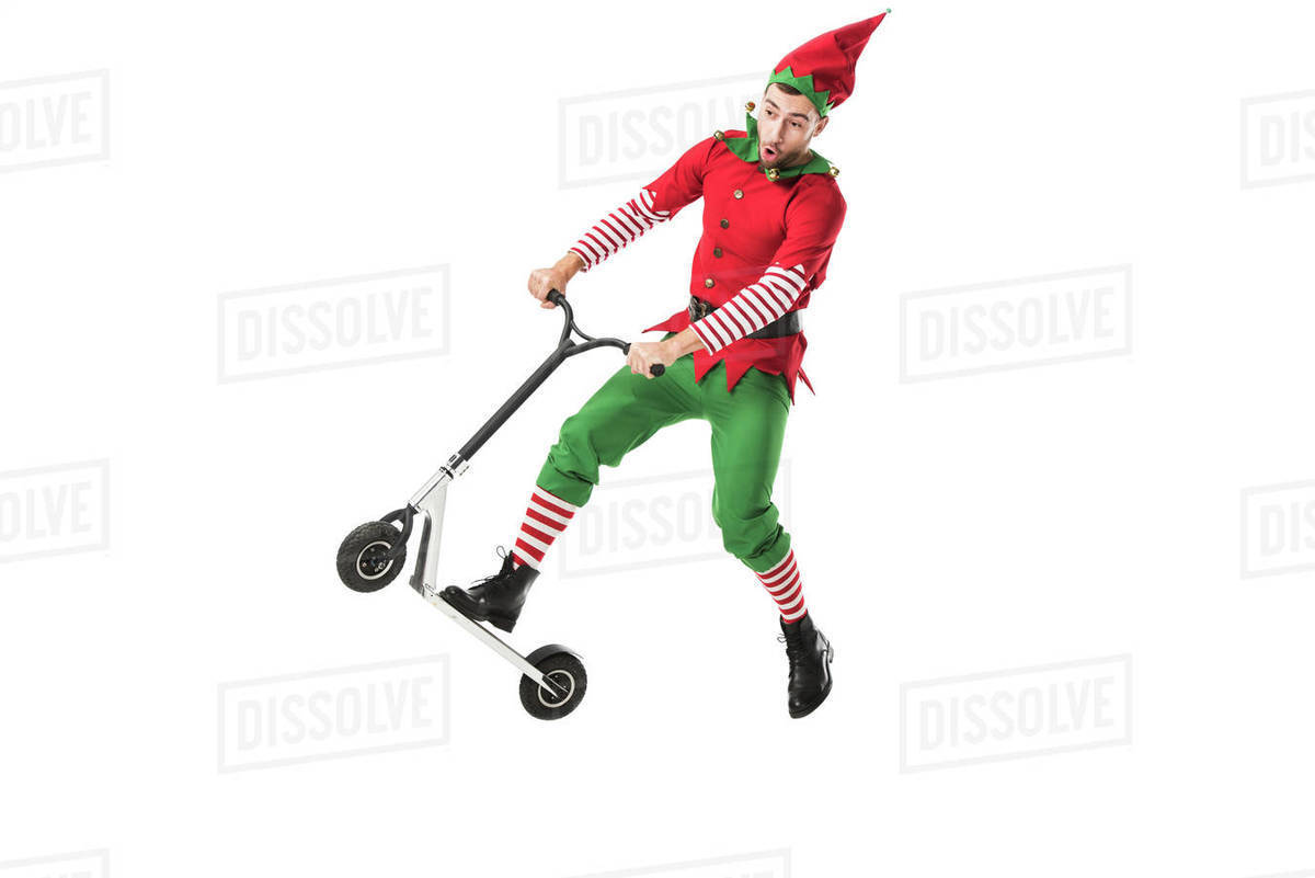 excited man in christmas elf costume jumping in air on push-cycle ...