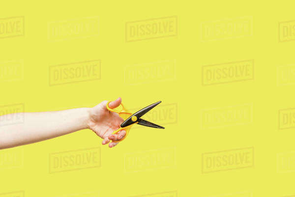 cropped shot of person holding scissors isolated on yellow - Royalty ...