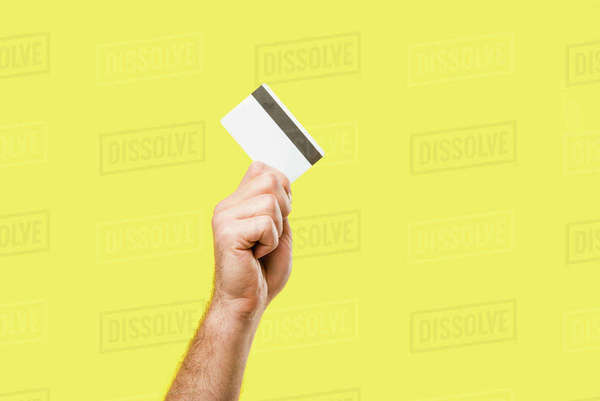 cropped shot of person holding credit card isolated on yellow - Royalty ...