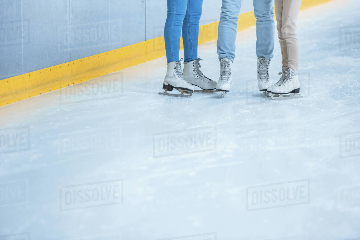 Partial view of family in skates standing on ice rink - Stock Photo ...