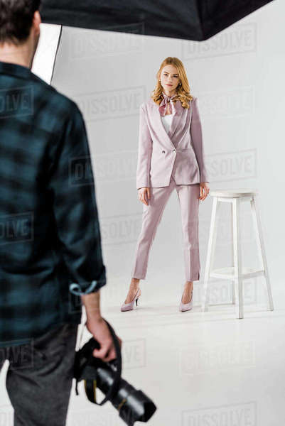 Cropped shot of photographer holding camera and beautiful female model ...