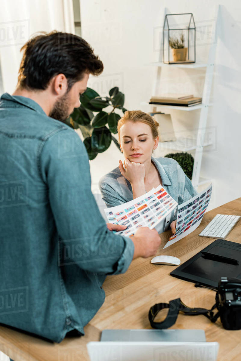 Professional young photographers discussing and checking photos for ...