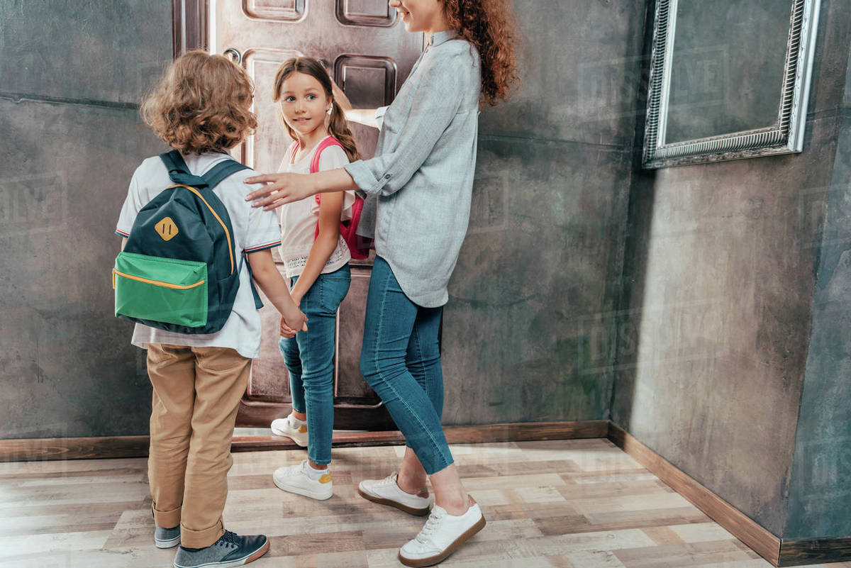Young mother seeing off her adorable little kids to school - Stock ...