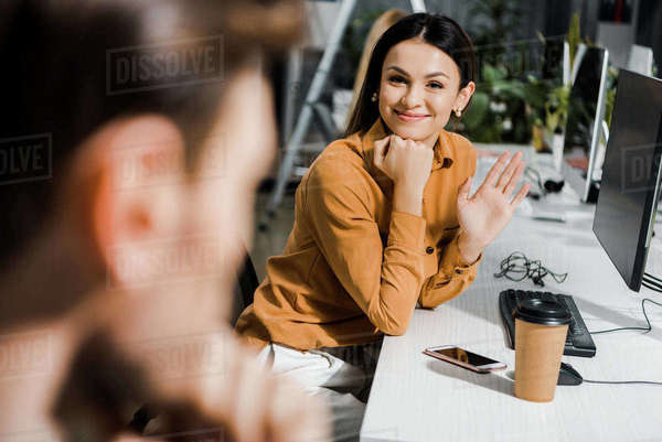 Smiling businesswoman greeting colleague at workplace in office ...