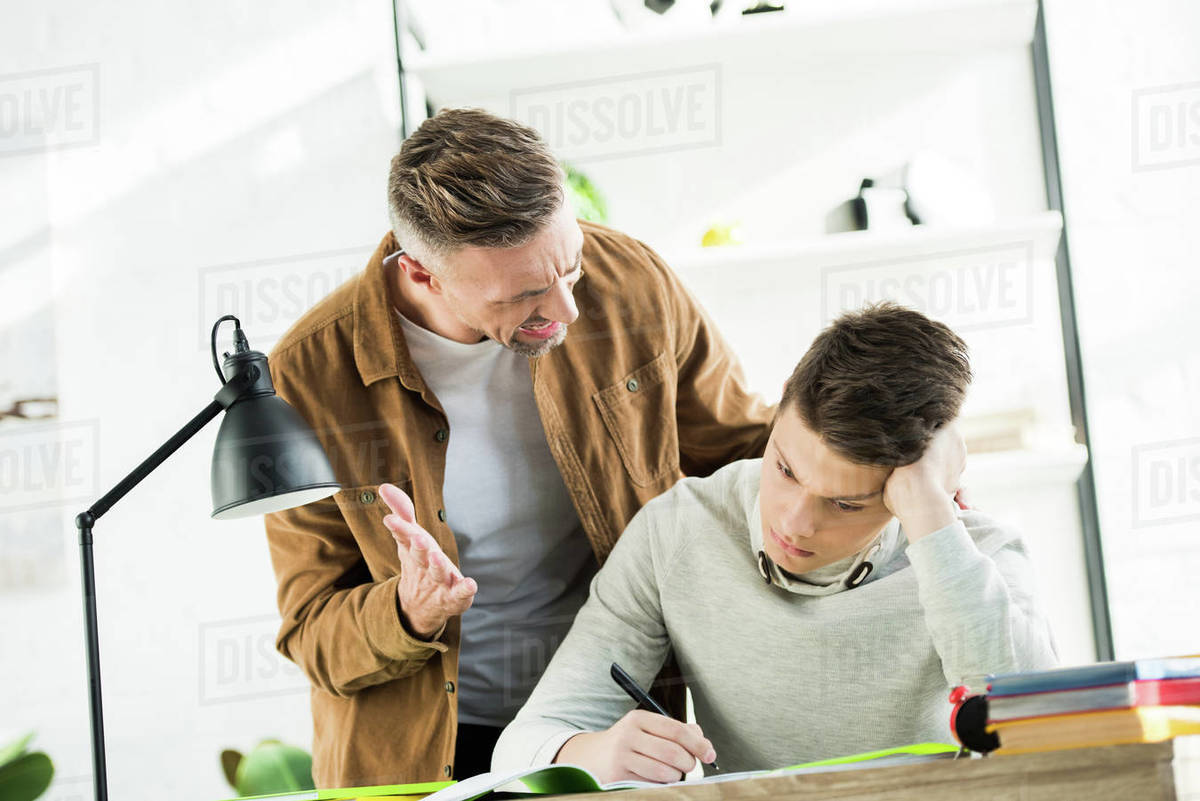 Angry father yelling at teen son, boy covering ears - Royalty-free ...