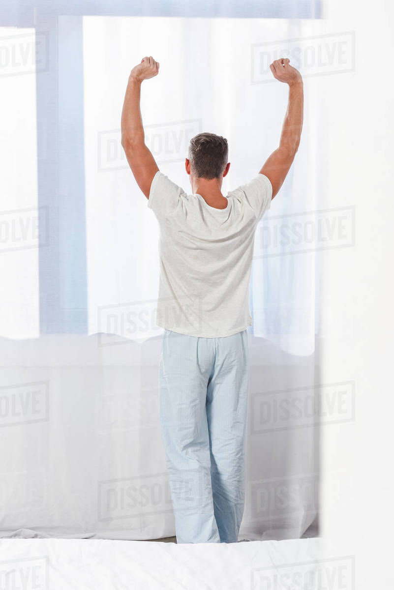 Back view of man stretching in room - Royalty-free Stock Photo | Dissolve