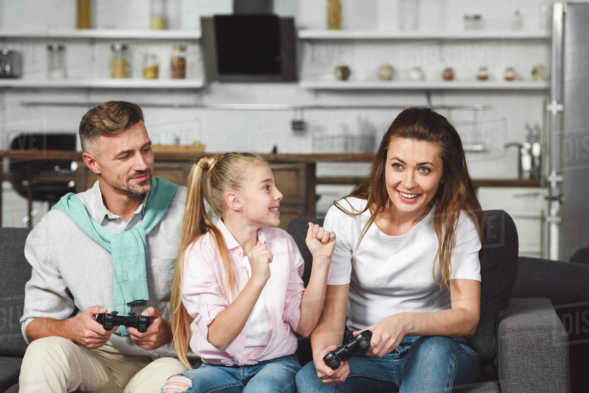 Happy family playing video game together in living room - Stock Photo ...