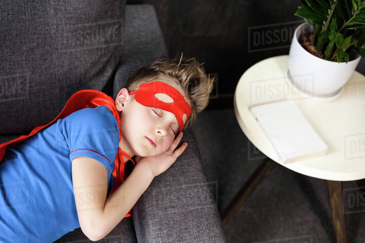 Little boy in red superhero costume sleeping on sofa - Royalty-free ...