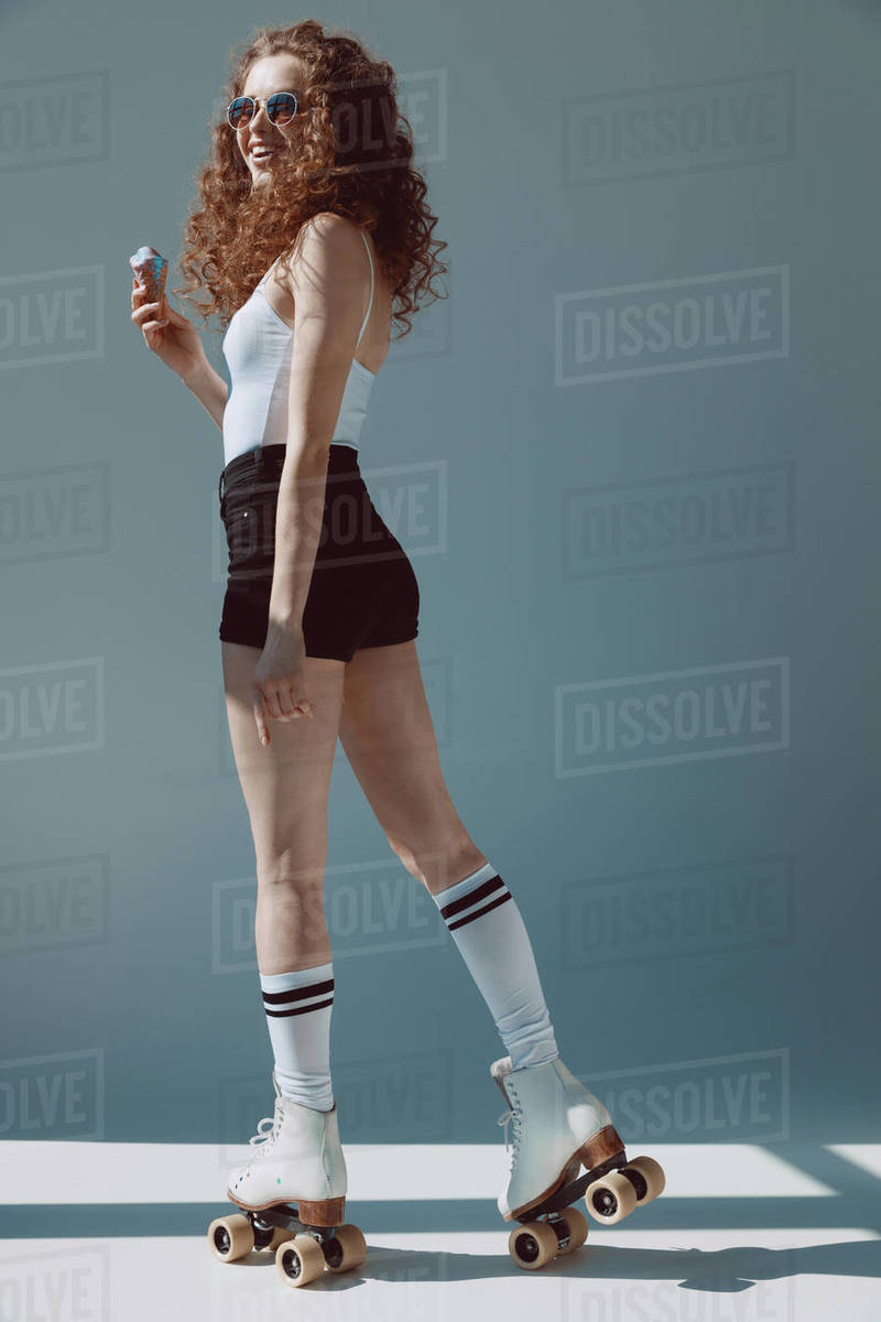Beautiful red hair girl on rollers eating ice cream, hipster girl ...