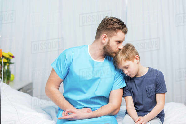 Sick father and upset son sitting together on hospital bed, dad and son ...