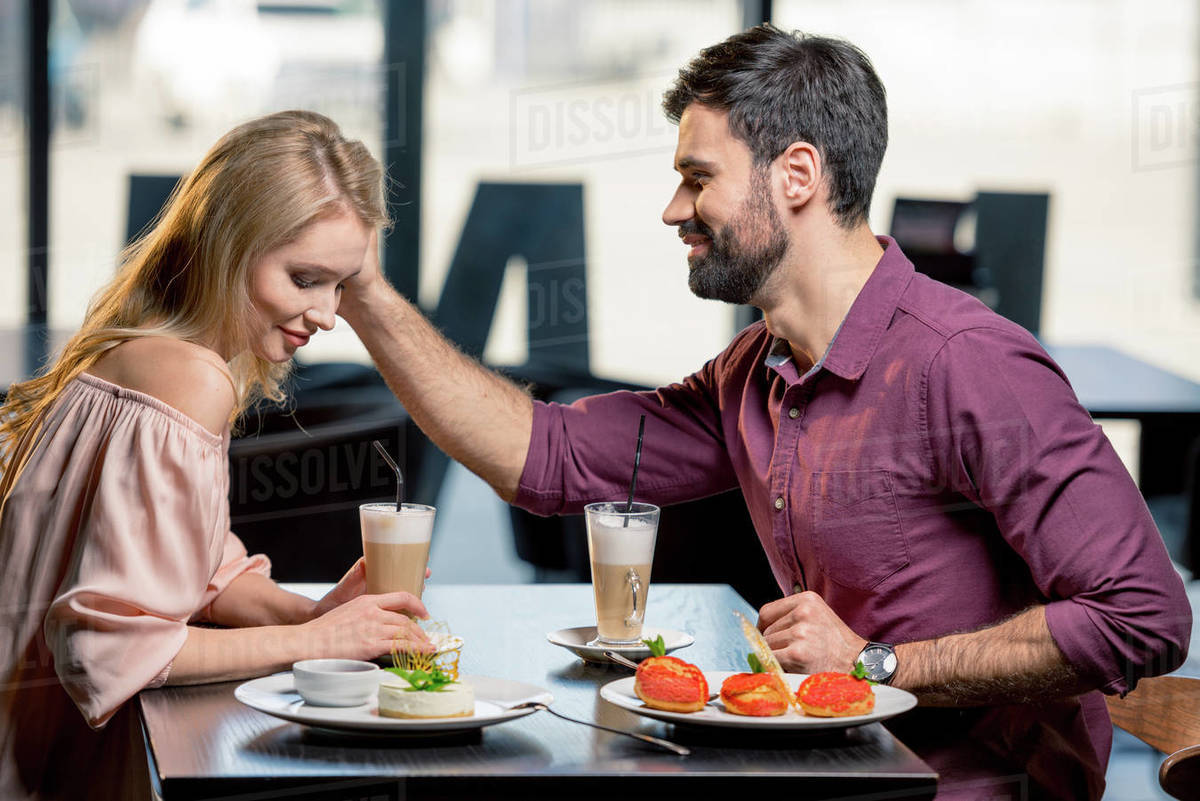 Side view of couple in love having lunch in restaurant together - Stock ...