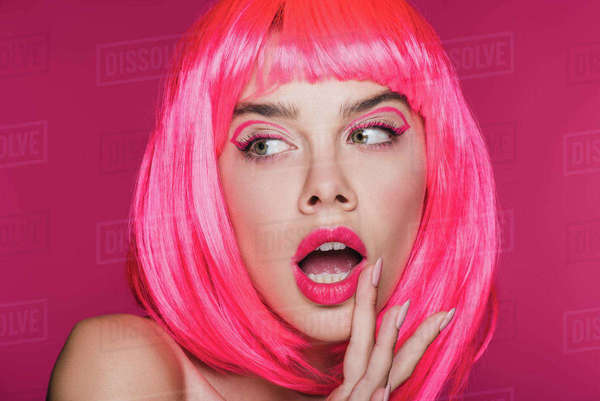 Beautiful shocked girl with makeup posing in neon pink wig, isolated on ...