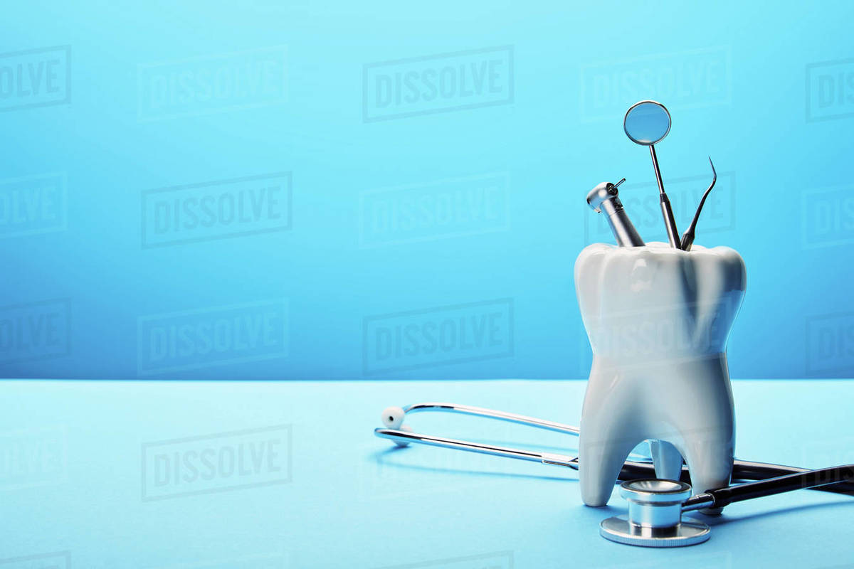Close up view of white tooth model, stethoscope and stainless dental ...