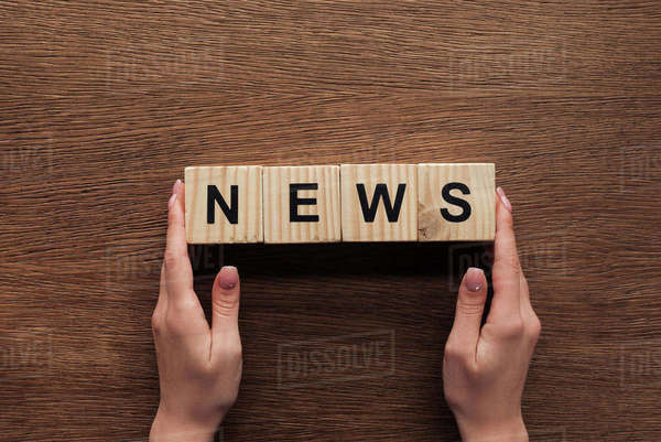 Cropped image of journalist holding wooden cubes with word news at ...
