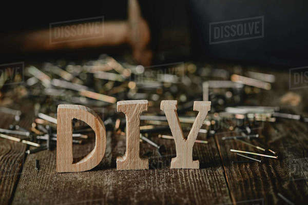 Close up of diy sign on dark wooden table on the background of nails ...