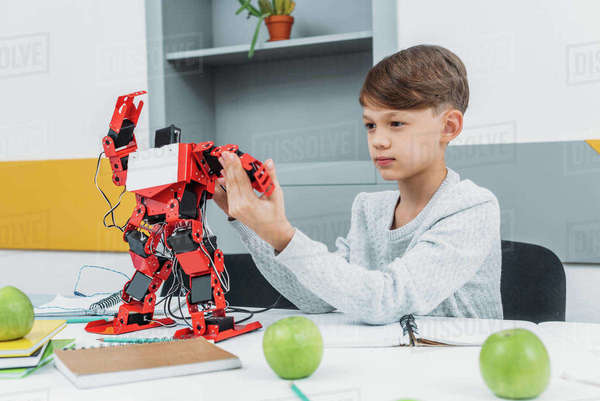 Attentive boy working with a robot at stem robotics lesson - Stock ...