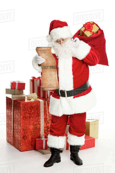 Happy Santa Claus standing with a pile of Christmas gifts and a big ...
