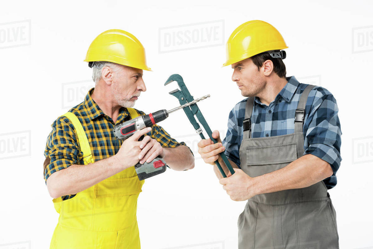 Two male construction workers fighting with tools and looking at each ...