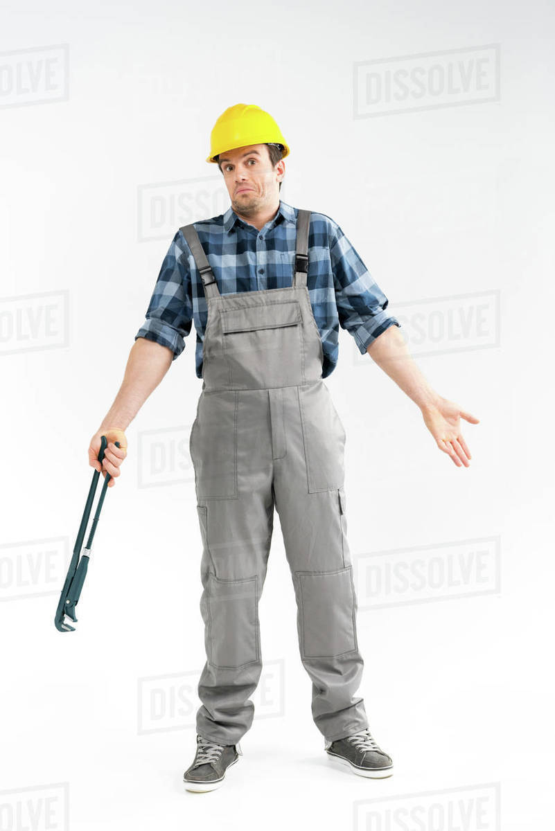 Full length portrait of confused professional male construction worker ...