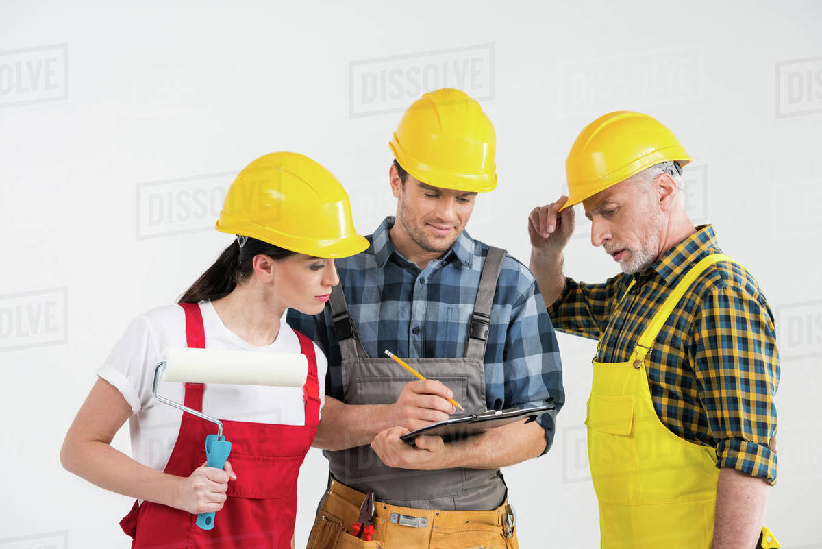 Group of professional male and female construction workers looking at ...