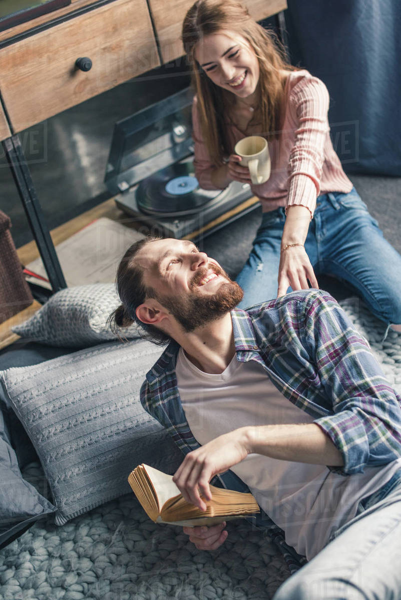 Happy young couple reading book together at home - Royalty-free Stock ...