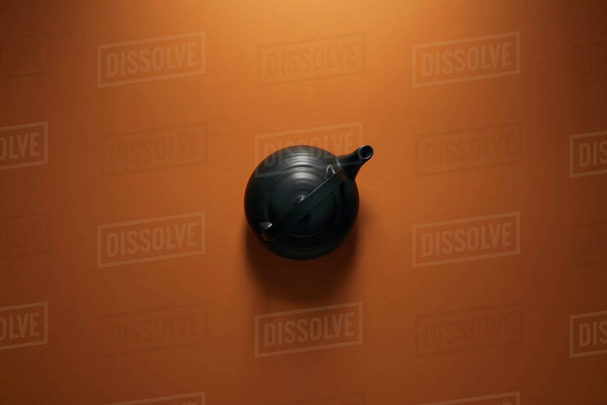 top view of black ceramic teapot on brown background - Stock Photo - Dissolve