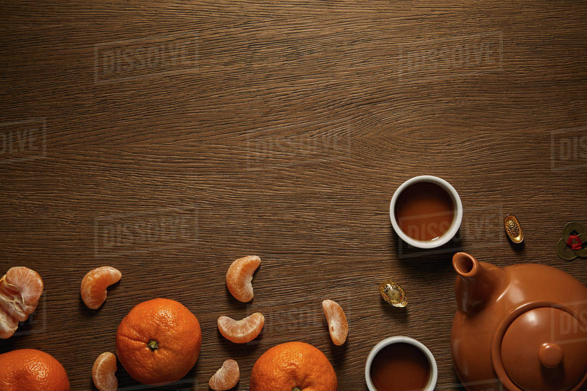 top view of tea set, tangerines and coins on wooden surface - Royalty ...