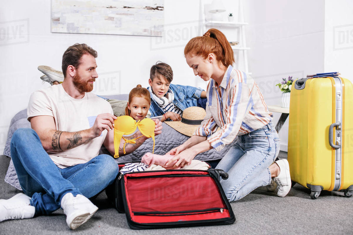 Happy family packing luggage for trip in bedroom - Royalty-free Stock ...