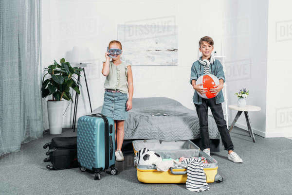 Adorable little kids packing clothes for trip on holidays - Royalty ...