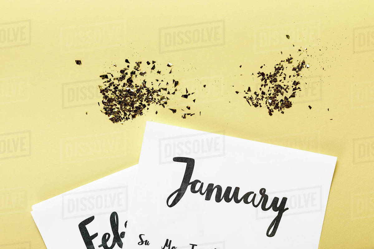Golden confetti with January and February calendar on beige background ...