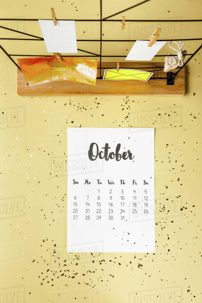 Top view of October calendar with golden confetti and cards with ...