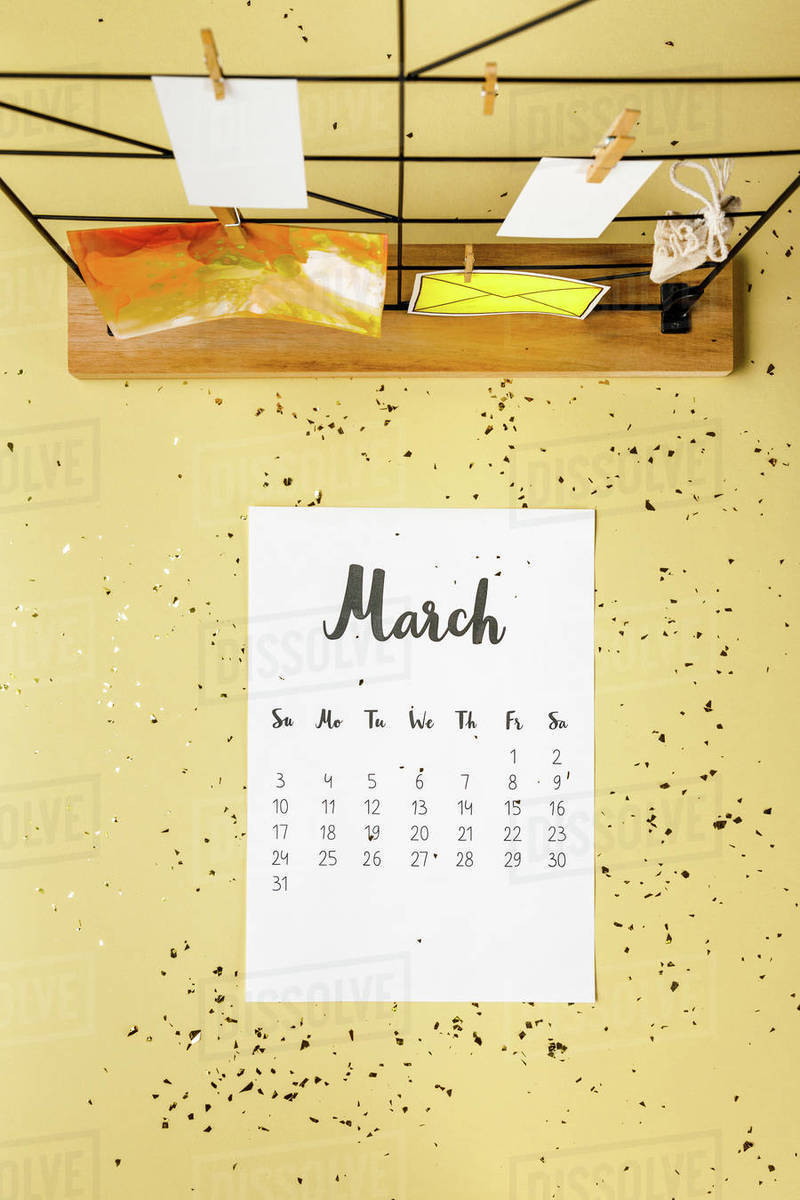 Top view of march calendar with golden confetti and cards with ...