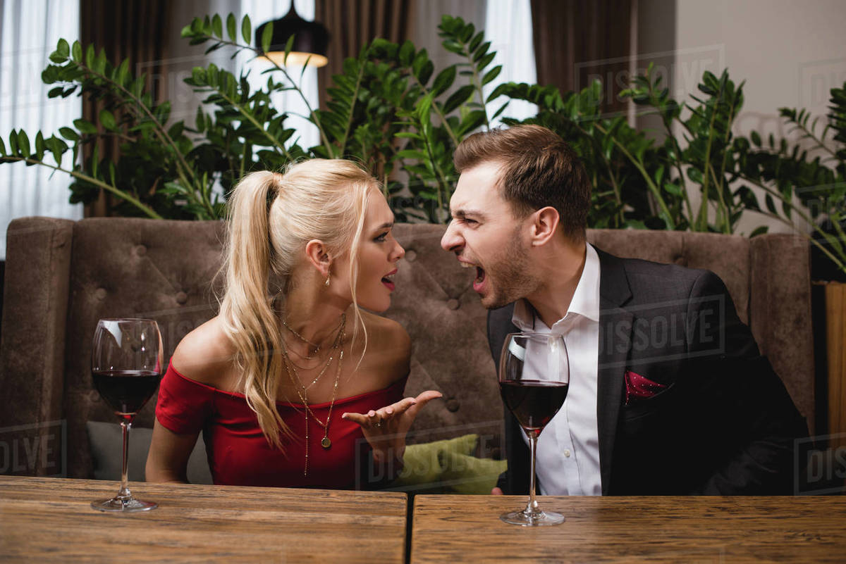 Couple screaming at each other while sitting in restaurant - Royalty ...